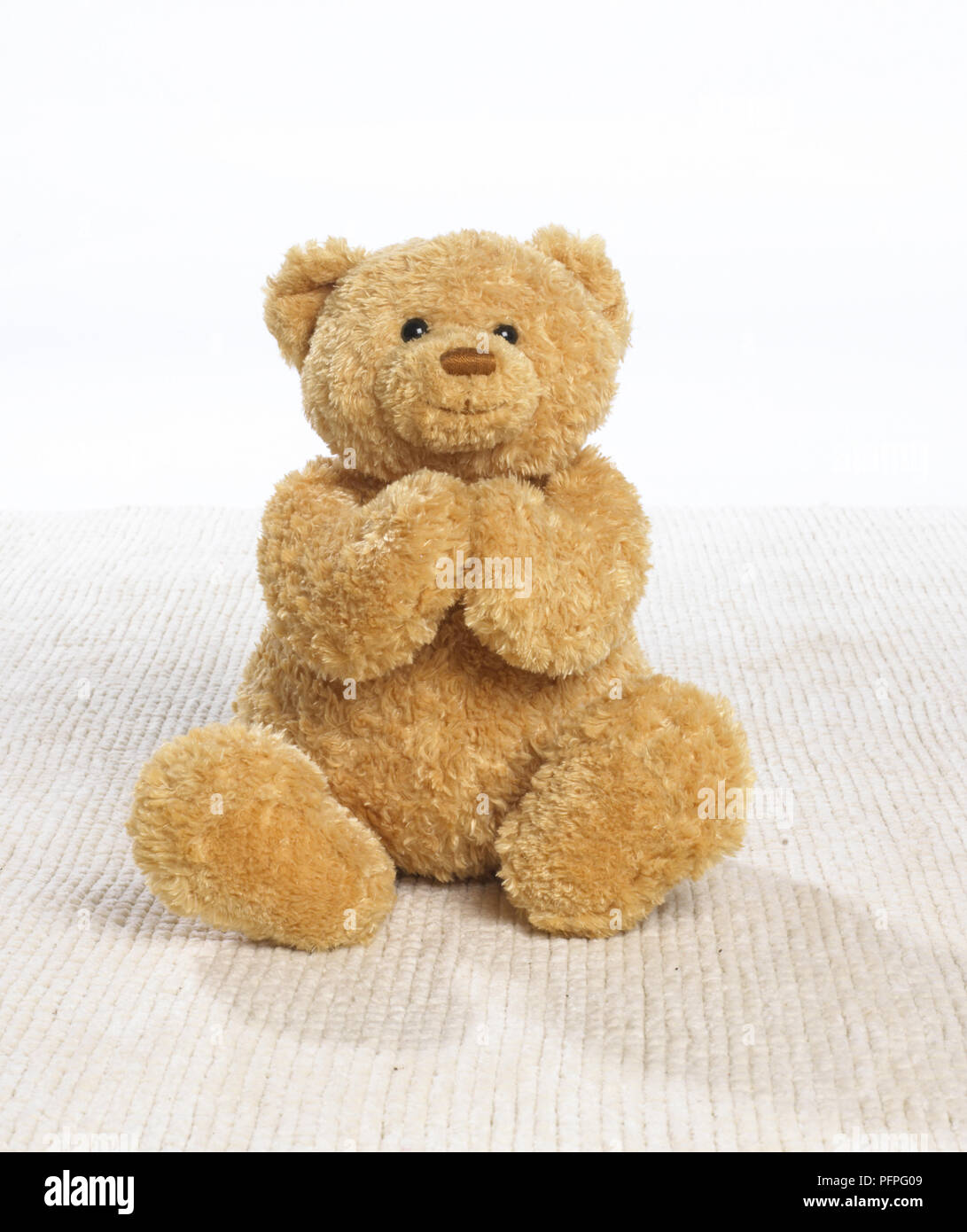 Teddy bear with paws together Stock Photo - Alamy