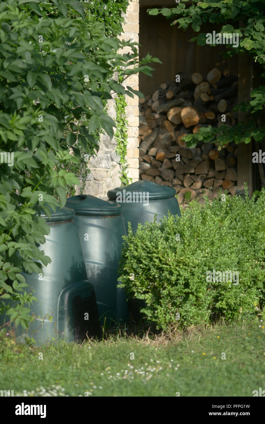Three green plastic compost bins by wall Stock Photo - Alamy