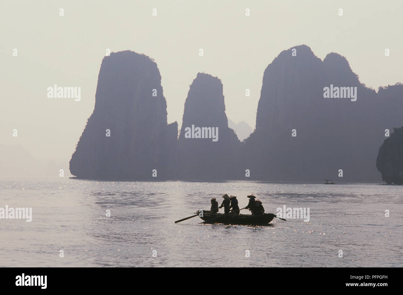 Vietnam, Bai Tu Long Bay, silhouette of people in rowing boat, Van Don ...