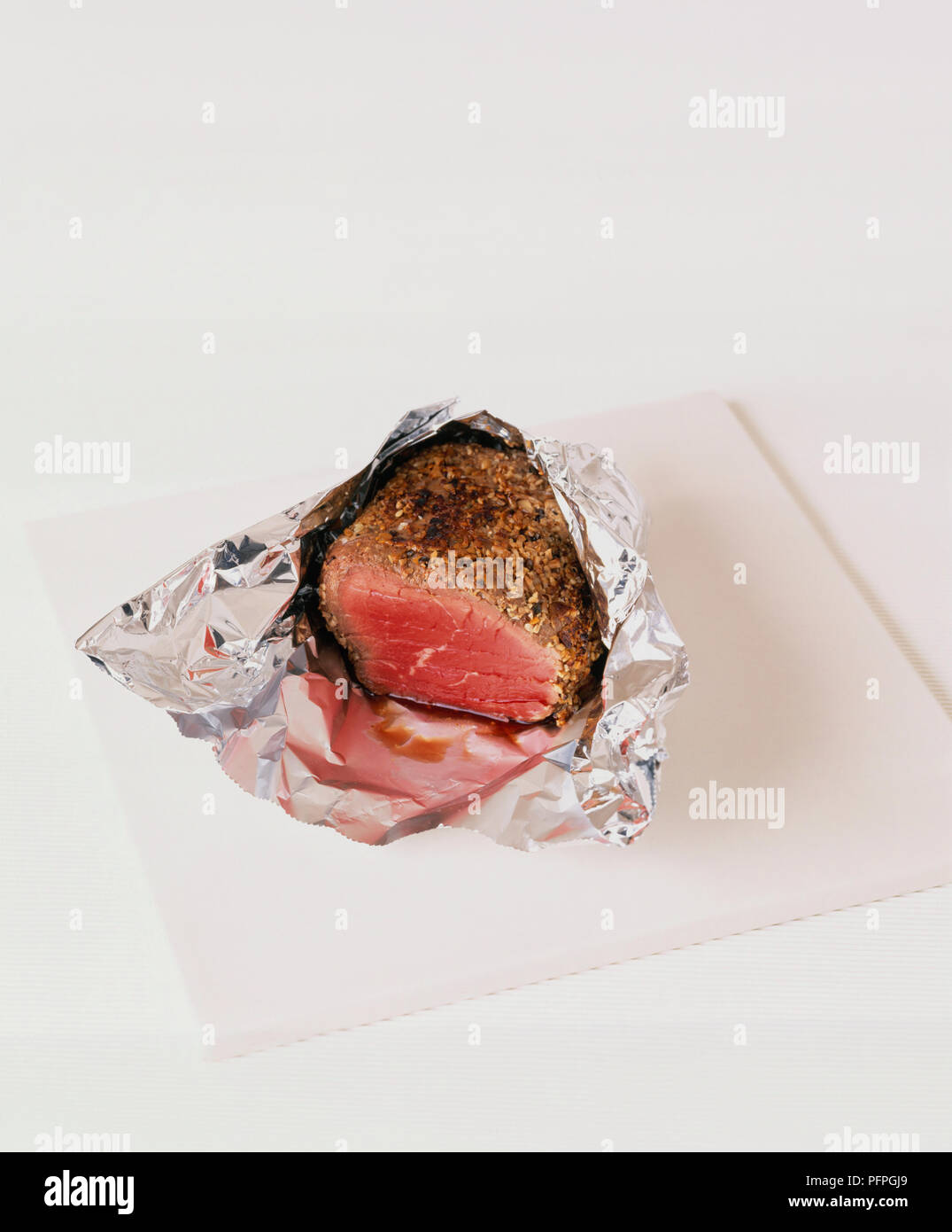 Beef cooked rare, coated with seeds wrapped in foil Stock Photo - Alamy
