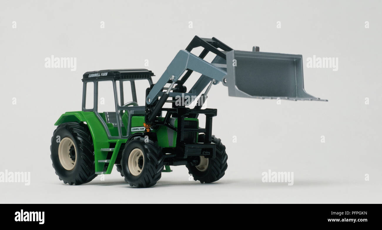 Green toy tractor with raised loader Stock Photo - Alamy