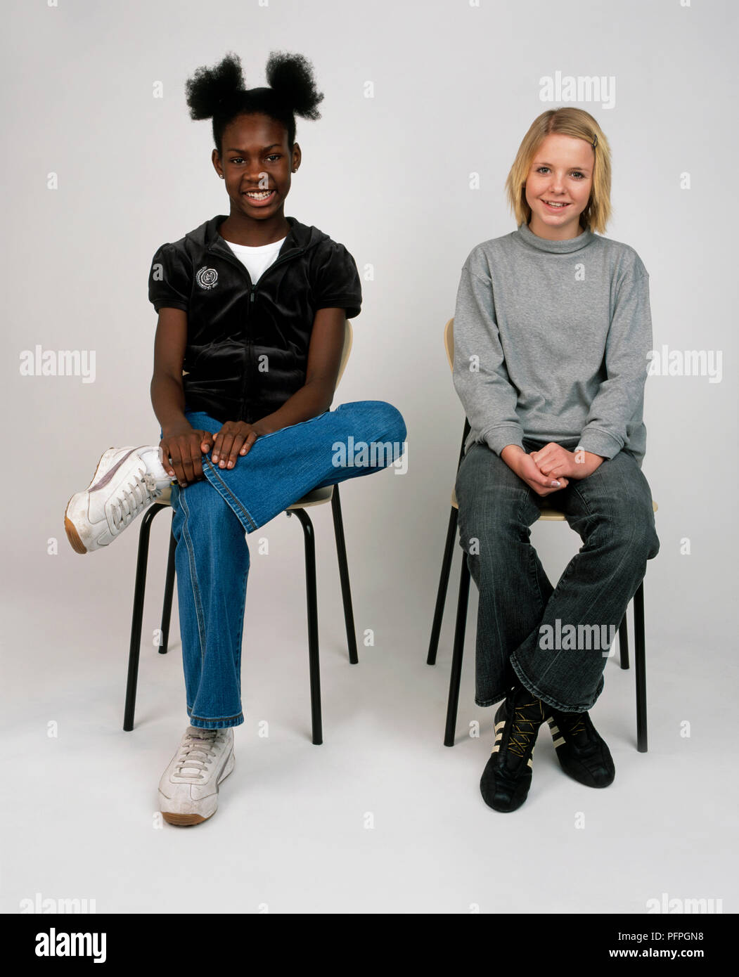 Two girls sitting on chairs hi-res stock photography and images - Alamy