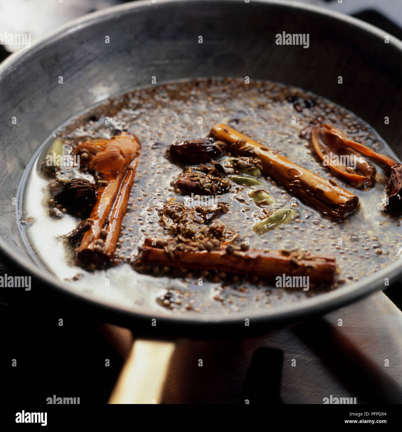 Whole spices fried in oil, including cinnamon, cardamom, cumin Stock ...