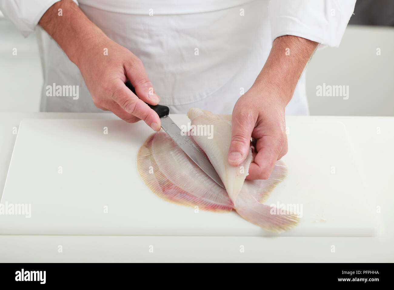 Cutting lemon sole into two fillets Stock Photo - Alamy