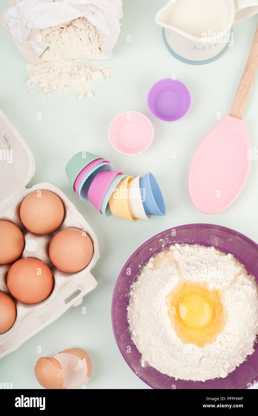 Baking ingredients and utensils, including box of eggs, egg an flour in ...