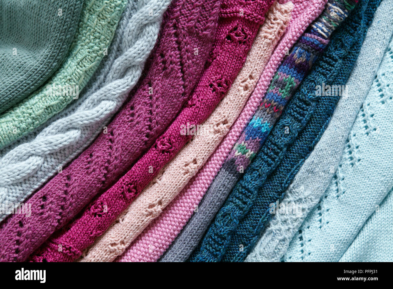 Knitted tops of different colours and stitches in a pile Stock Photo ...