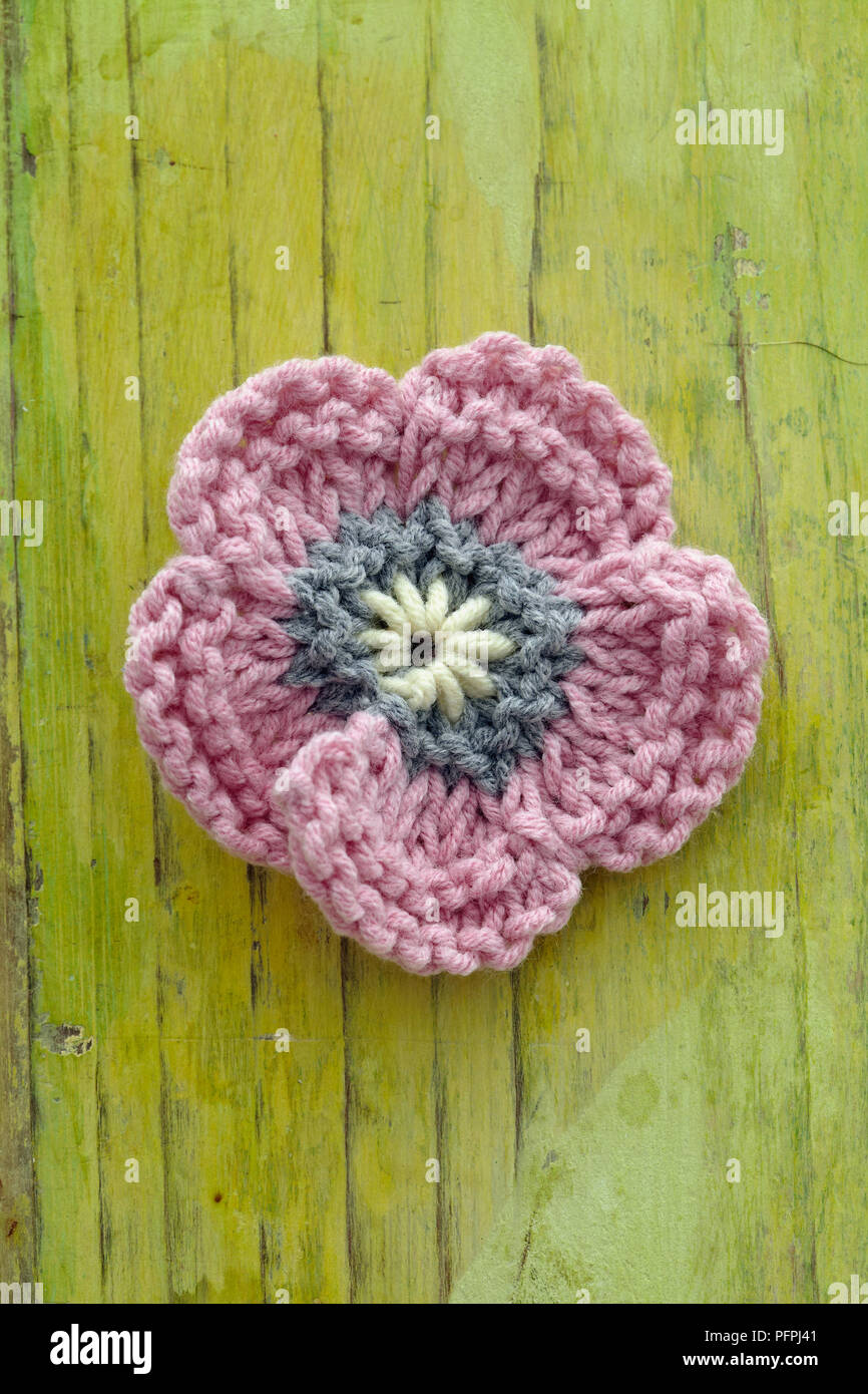Pink knitted flower on green wood background Stock Photo - Alamy