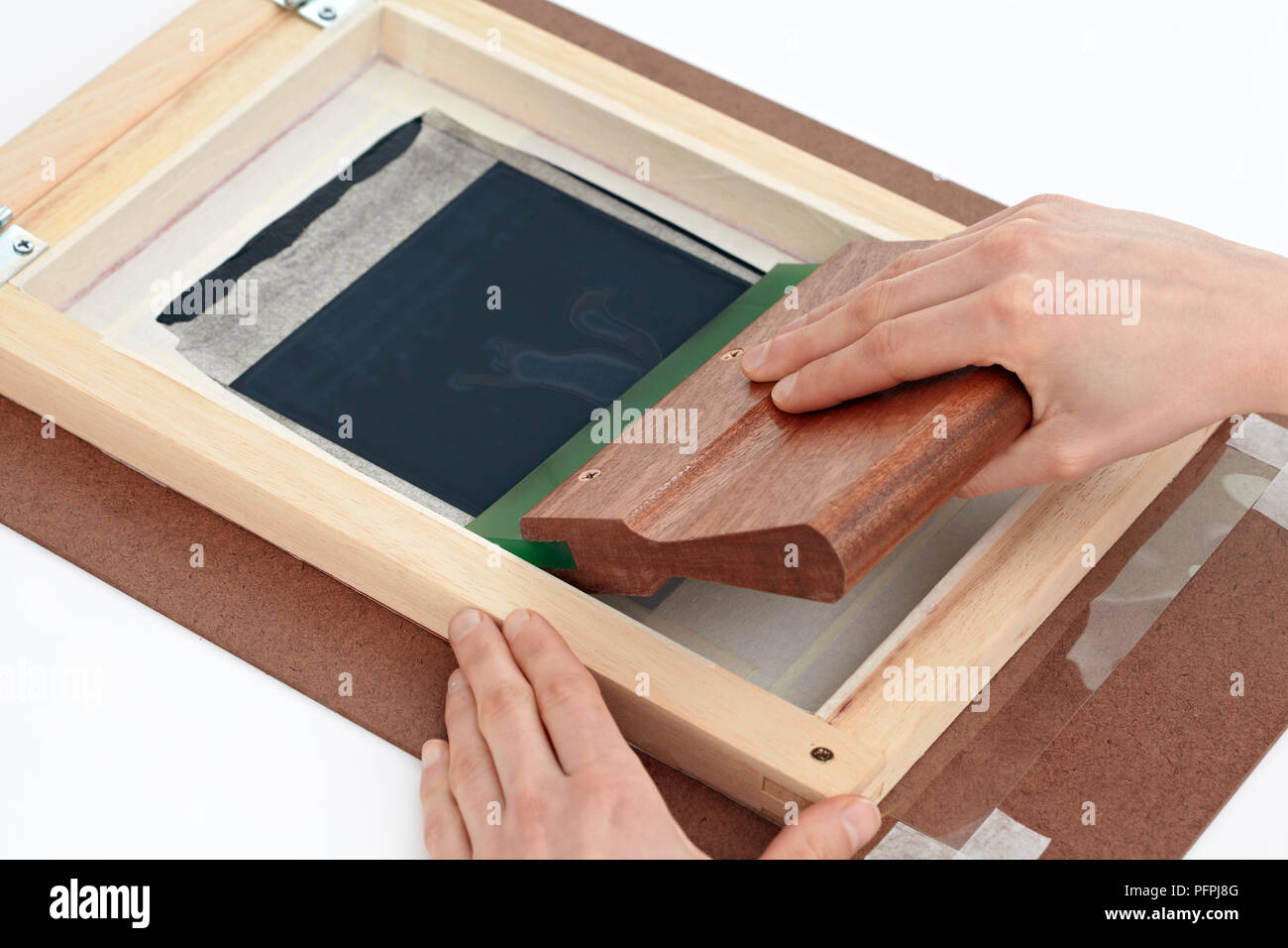 Using squeegee to pull ink across stencil on screen, close-up Stock ...