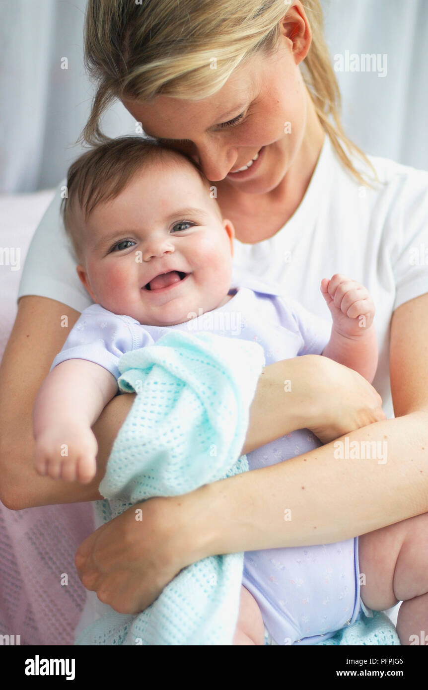 Woman hugging baby, baby smiling and looking at camera Stock Photo - Alamy