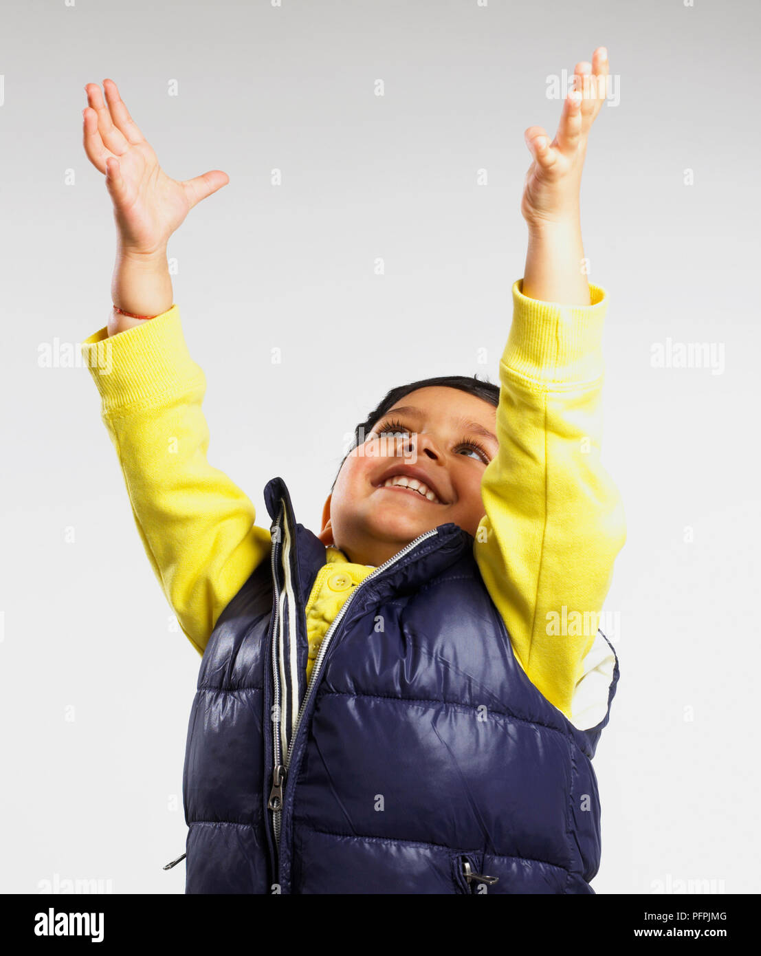 Boy raising both his hands, looking up Stock Photo - Alamy