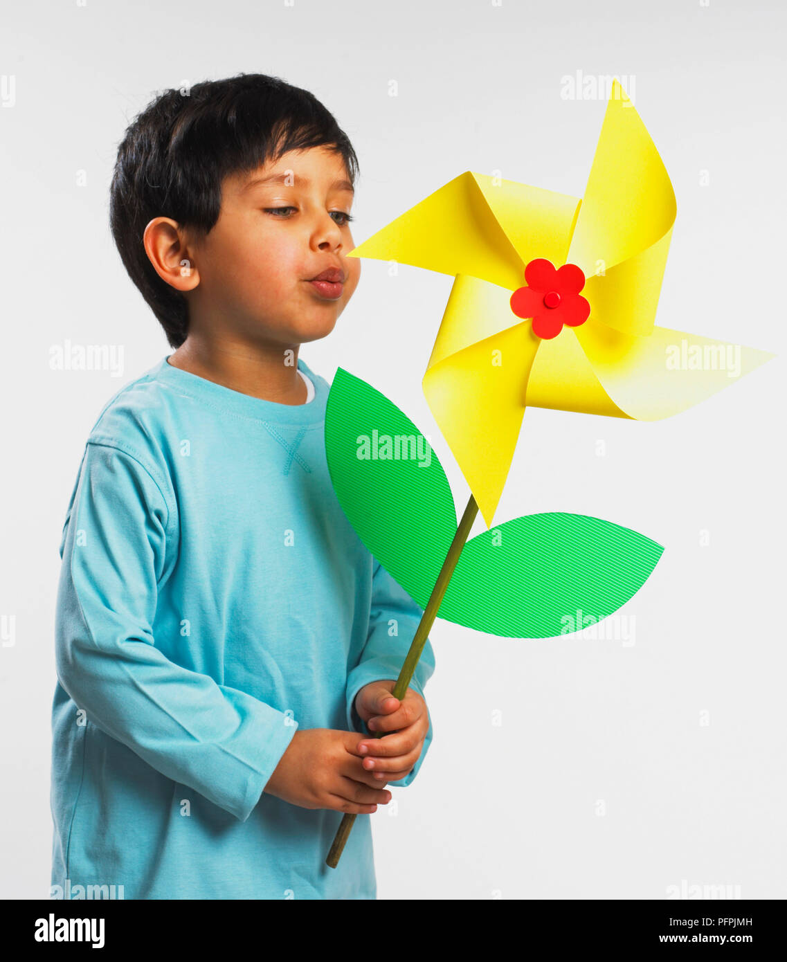 Boy blowing on paper windmill Stock Photo - Alamy