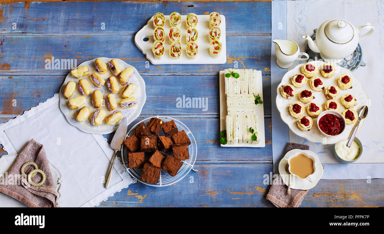 Assorted, sweet and savoury afternoon tea treats on wood background ...