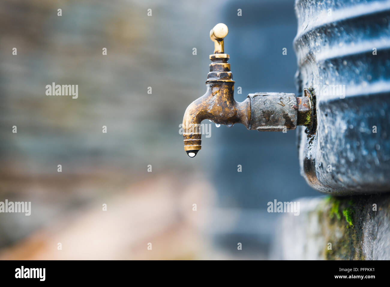Dripping tap attached to a water tank Stock Photo - Alamy
