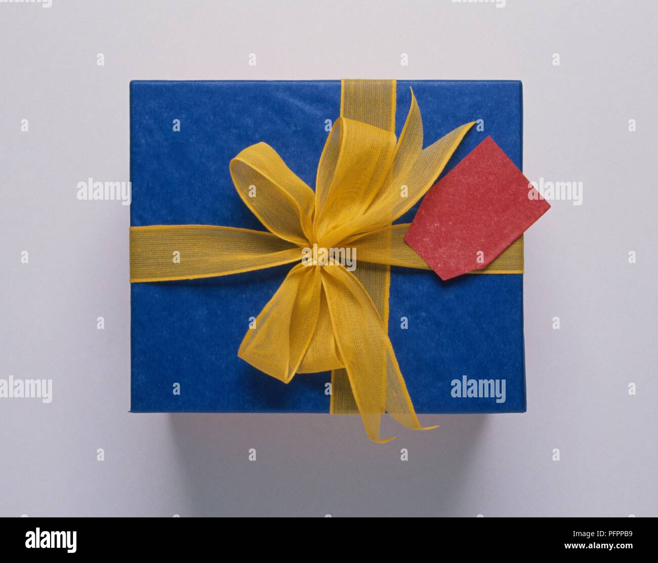 Blue birthday present with yellow ribbon and red gift tag Stock Photo ...