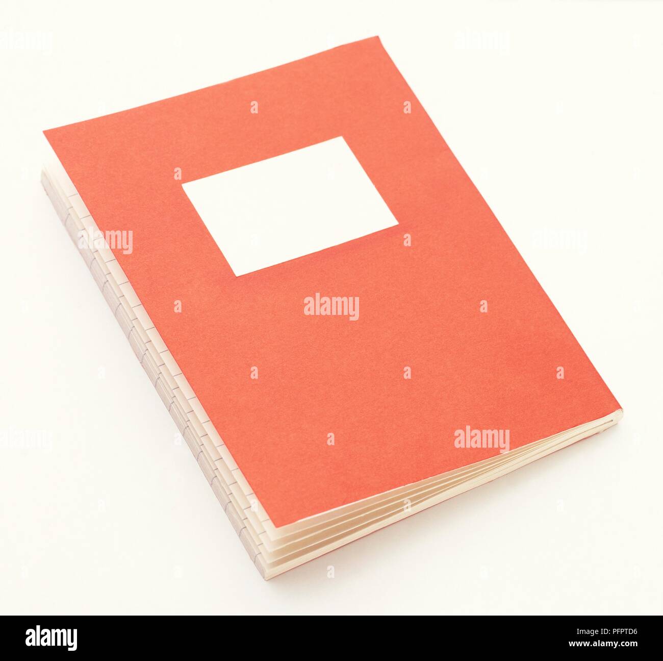 Red lined exercise book with white label on the back Stock Photo - Alamy