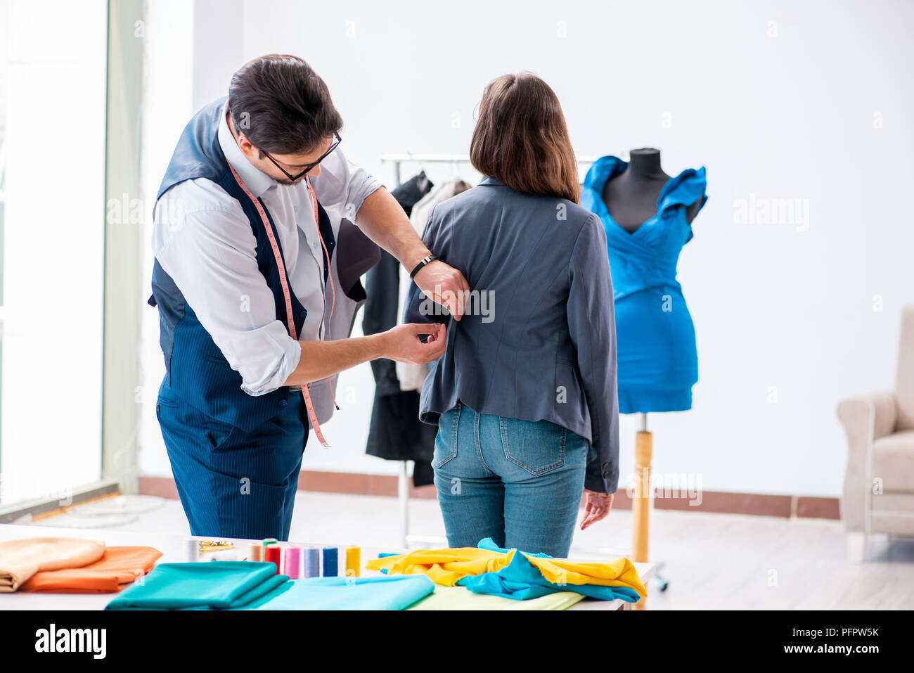 Professional tailor taking measurements for formal suit Stock Photo - Alamy