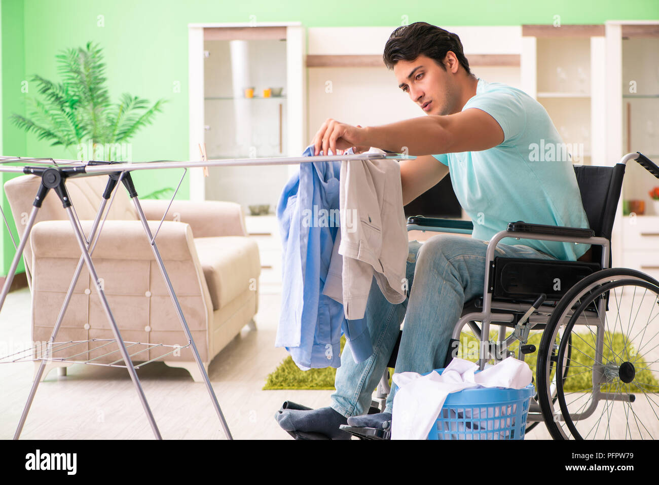Disabled man on wheelchair doing laundry Stock Photo - Alamy