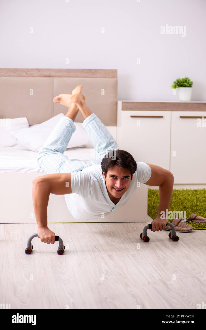 Young man doing morning routine in bedroom Stock Photo - Alamy