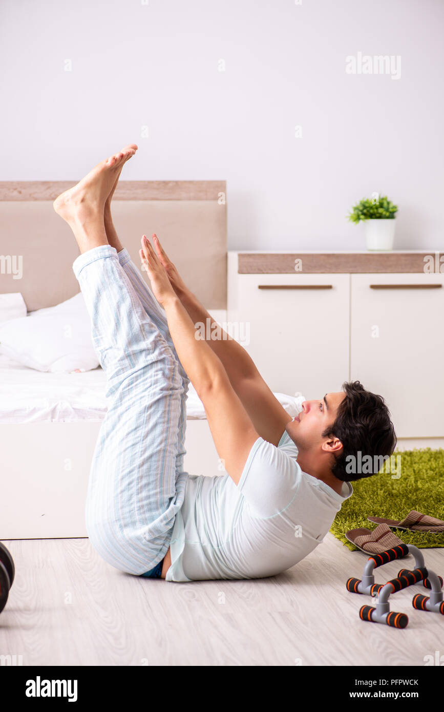 Young man doing morning routine in bedroom Stock Photo - Alamy
