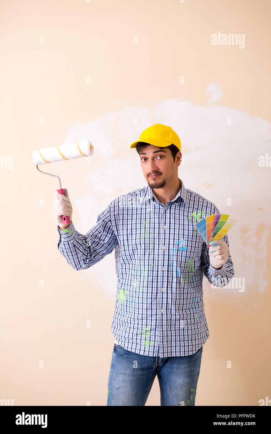 Painter man painting the wall at home Stock Photo - Alamy