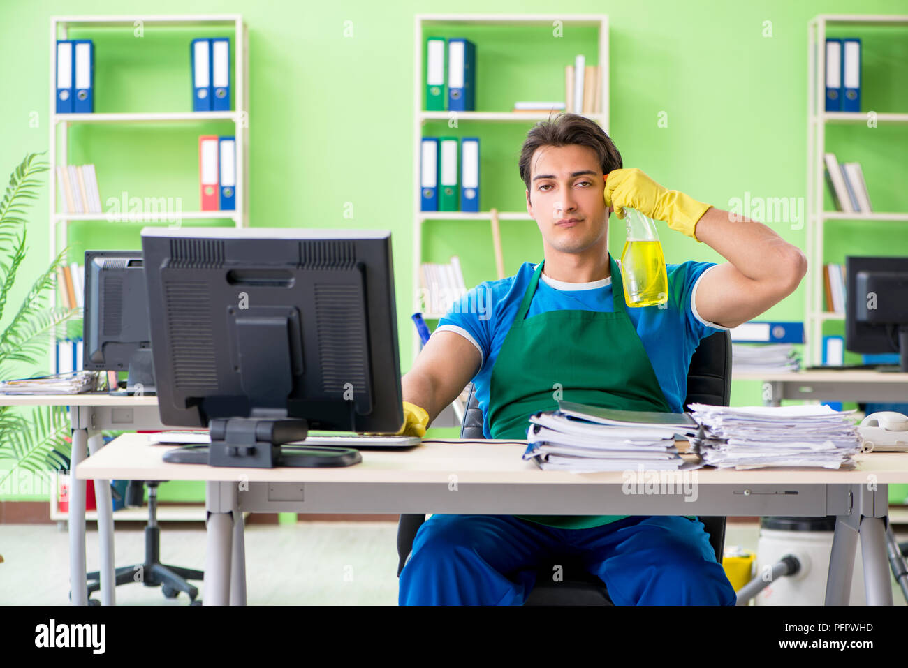 Handsome man cleaning office with vacuum cleaner Stock Photo - Alamy