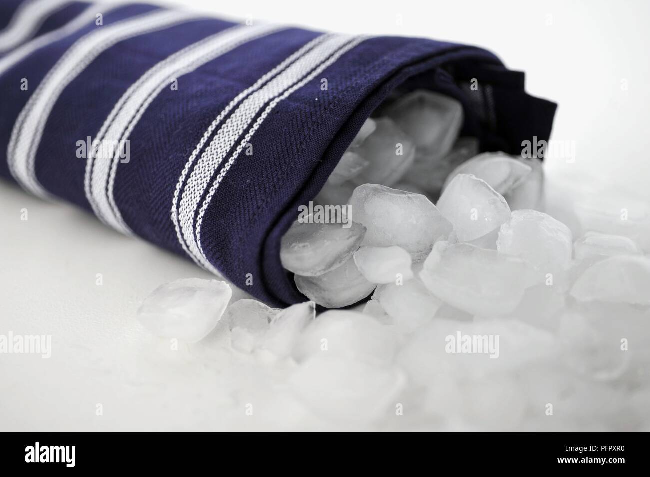 Ice wrapped and spilling out of rolled up fabric Stock Photo - Alamy