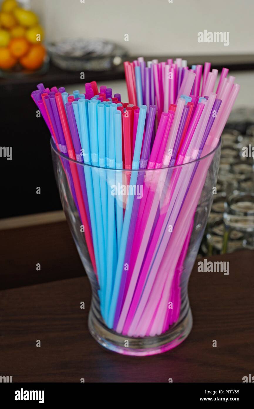 Colourful drinking straws in glass on bar counter Stock Photo - Alamy