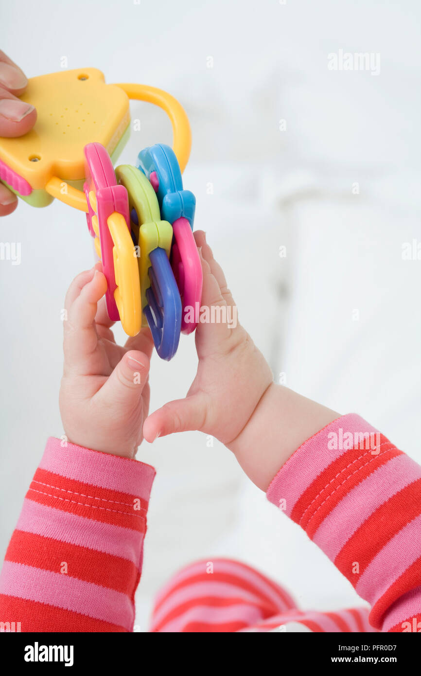 Baby reaching for plastic ring toy Stock Photo - Alamy