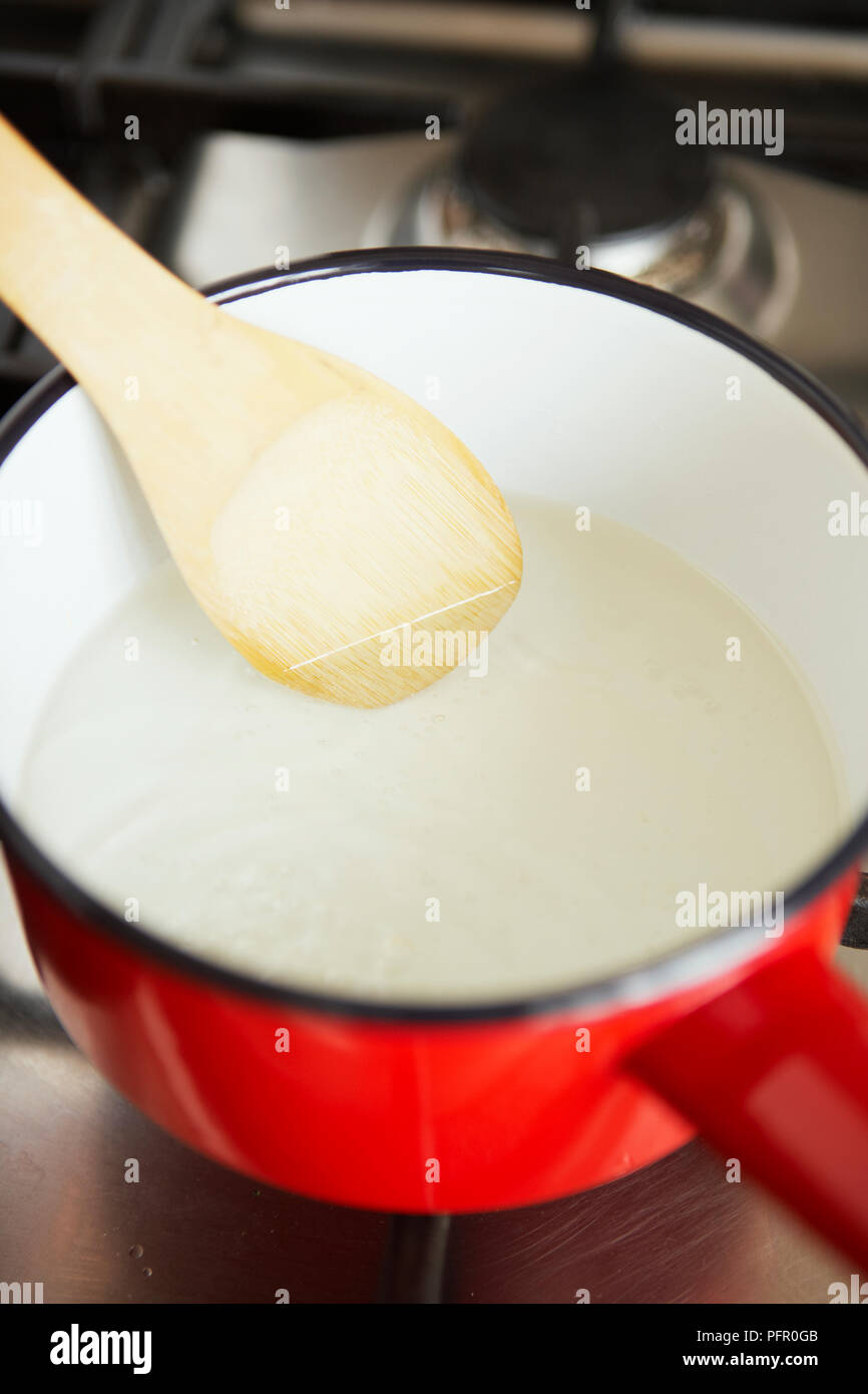 Heating sugar and water in saucepan on gas hob to make syrup Stock ...