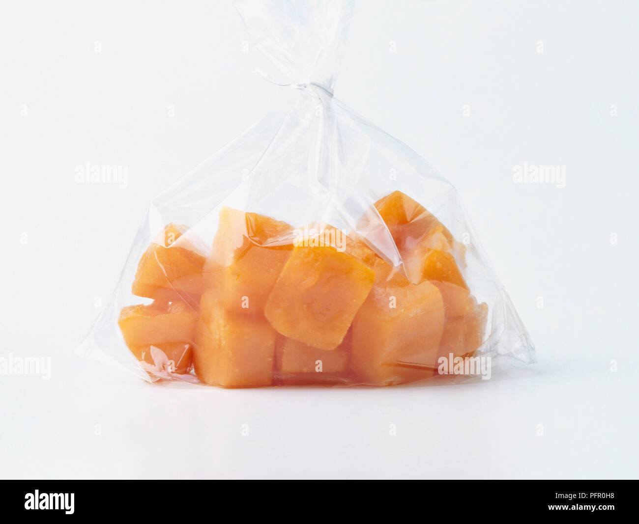 Frozen pureed carrot cubes in tied-up transparent plastic freezer bag ...