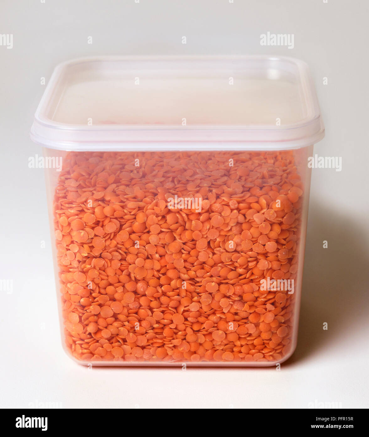 Red split lentils in plastic container with lid on Stock Photo - Alamy