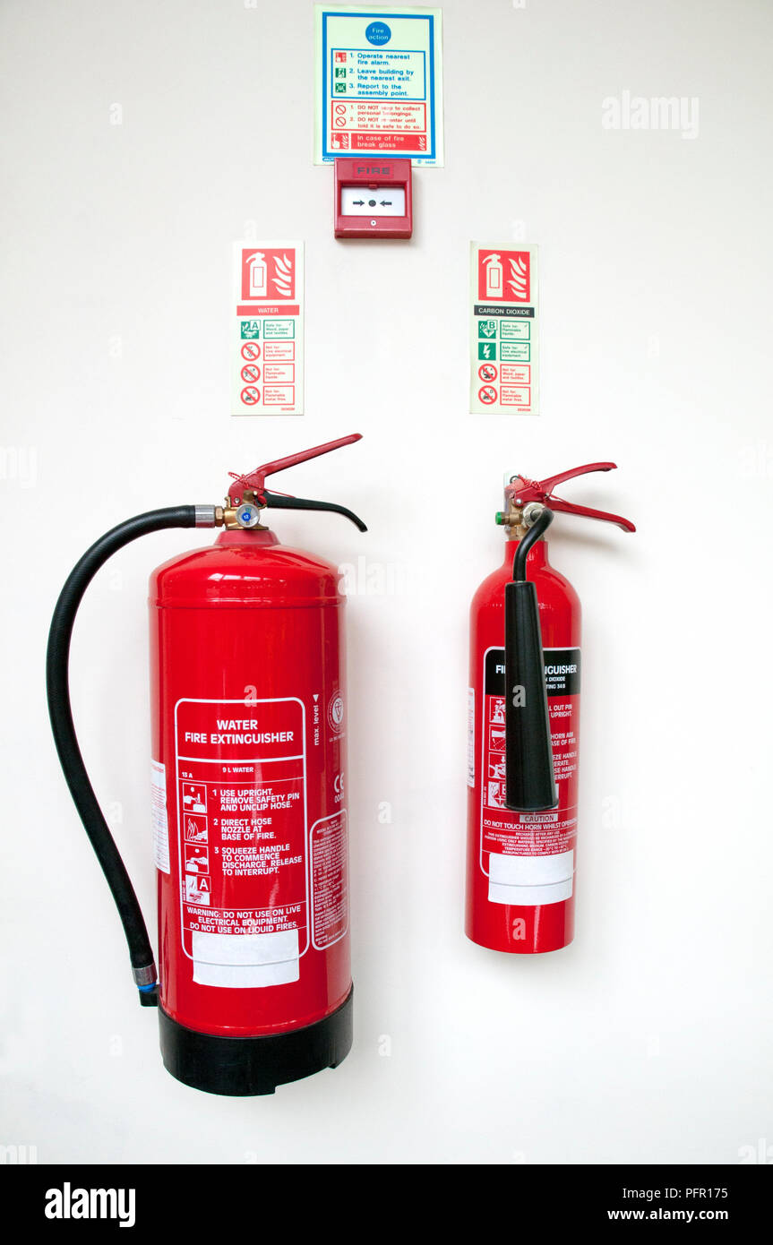 Two fire extinguishers, fire alarm, and safety signs Stock Photo - Alamy