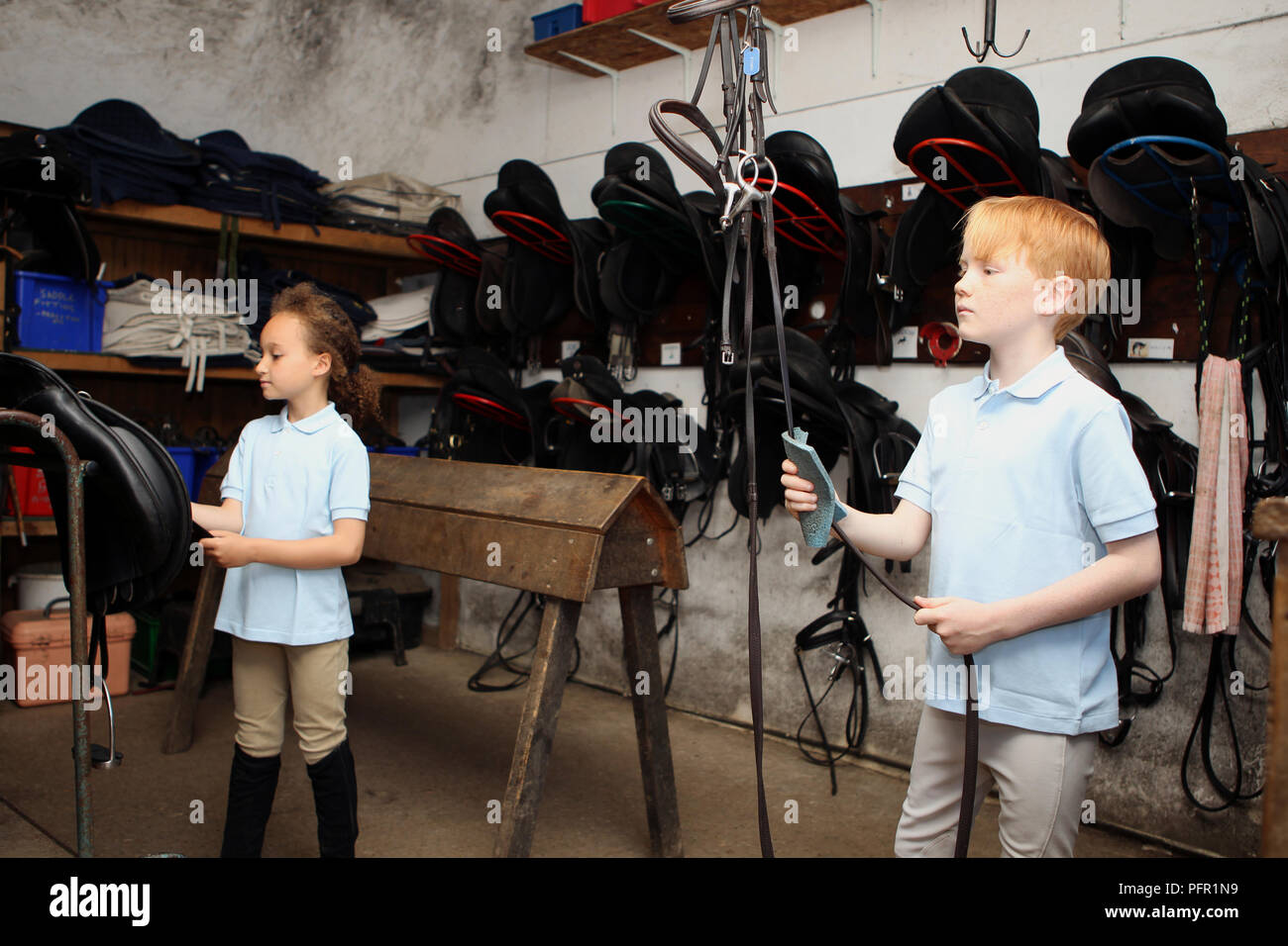 Two children in tack room Stock Photo - Alamy