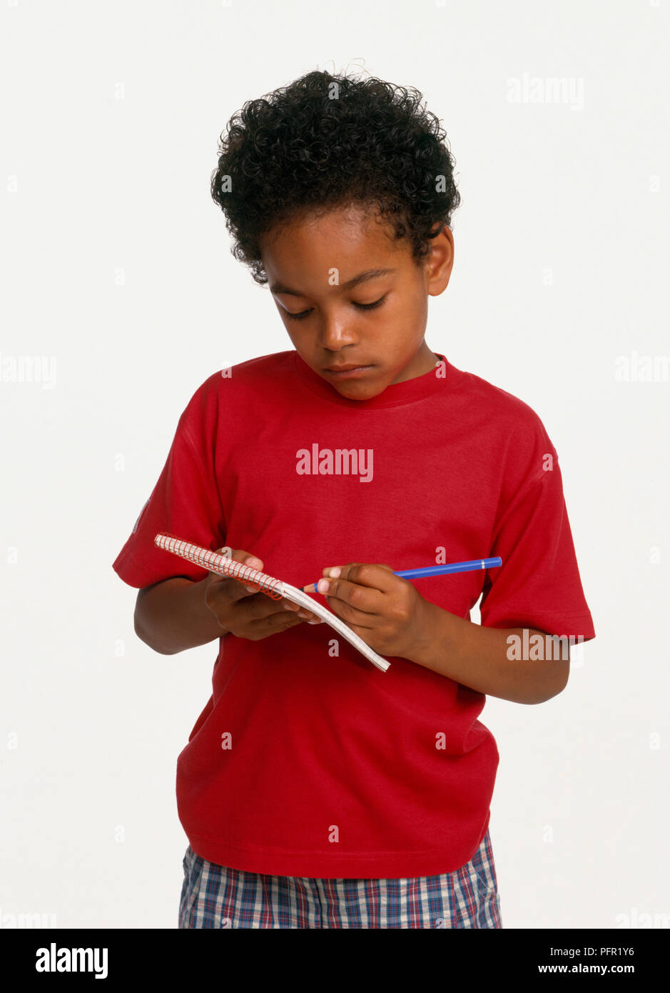 Boy writing on notepad Stock Photo - Alamy