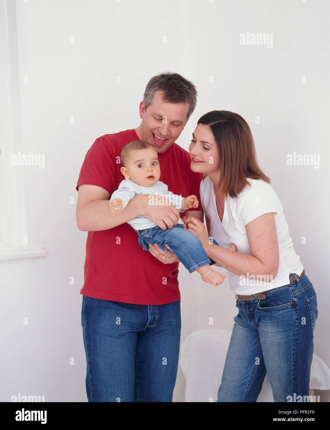 Woman and man holding baby boy (7 months Stock Photo - Alamy