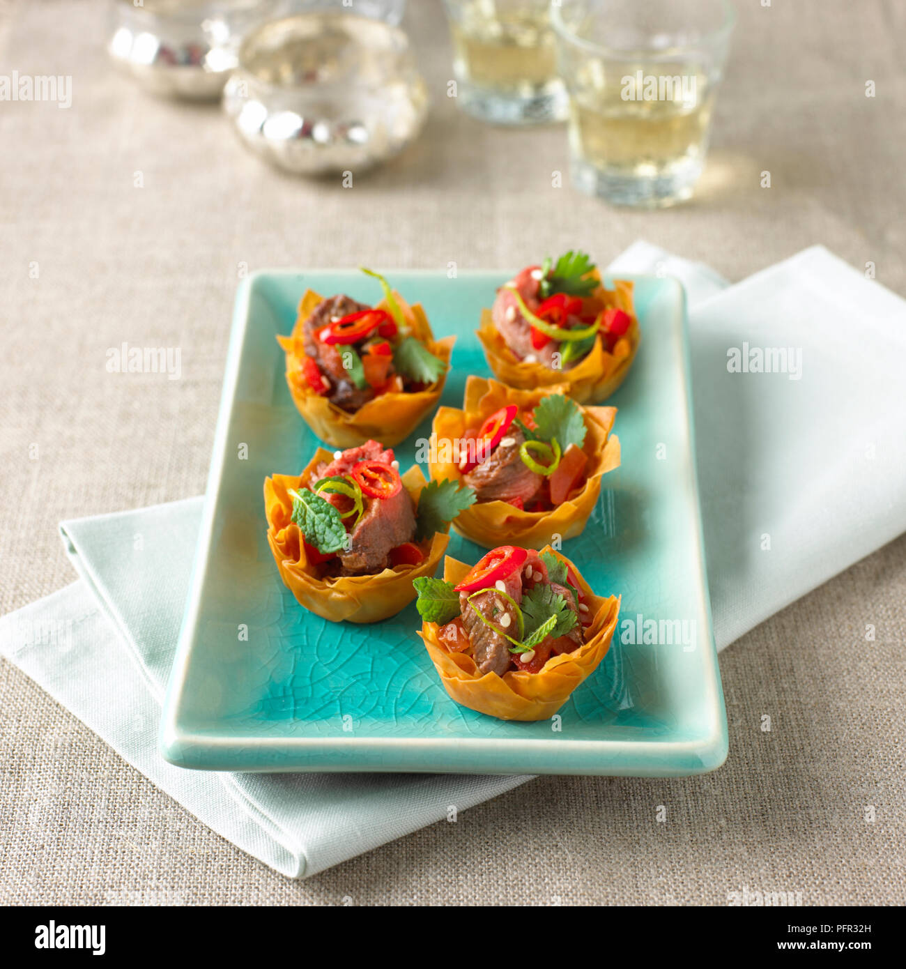Filo pastry filled with Asian beef salad and garnished with peppers ...