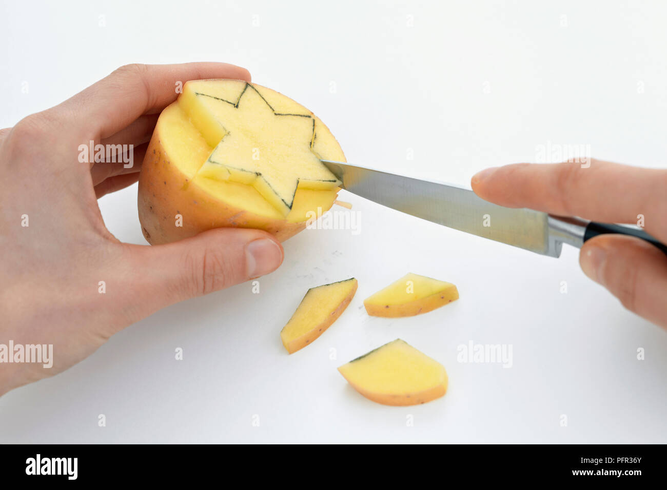 Cutting out a star shape from a potato to make potato prints Stock ...