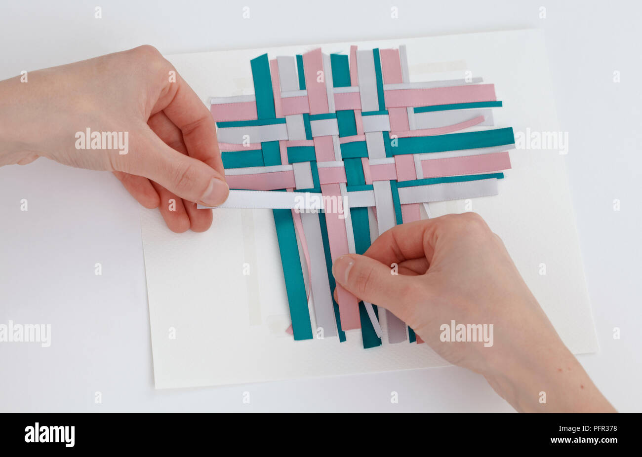 Creating a ribbon weave pattern using coloured strips of paper Stock ...