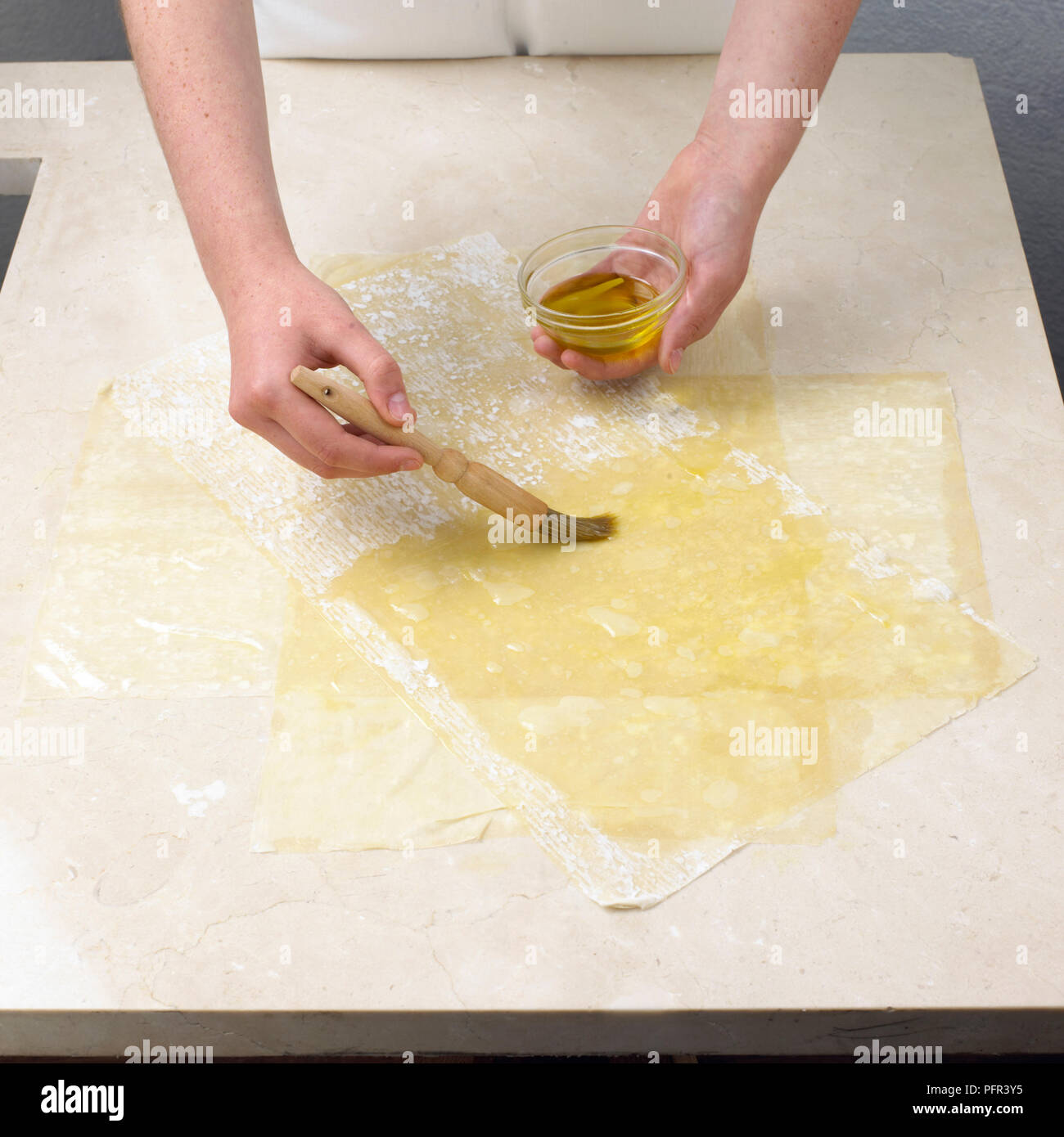 Making a pastilla pastry parcel, layering sheets of filo pastry and ...