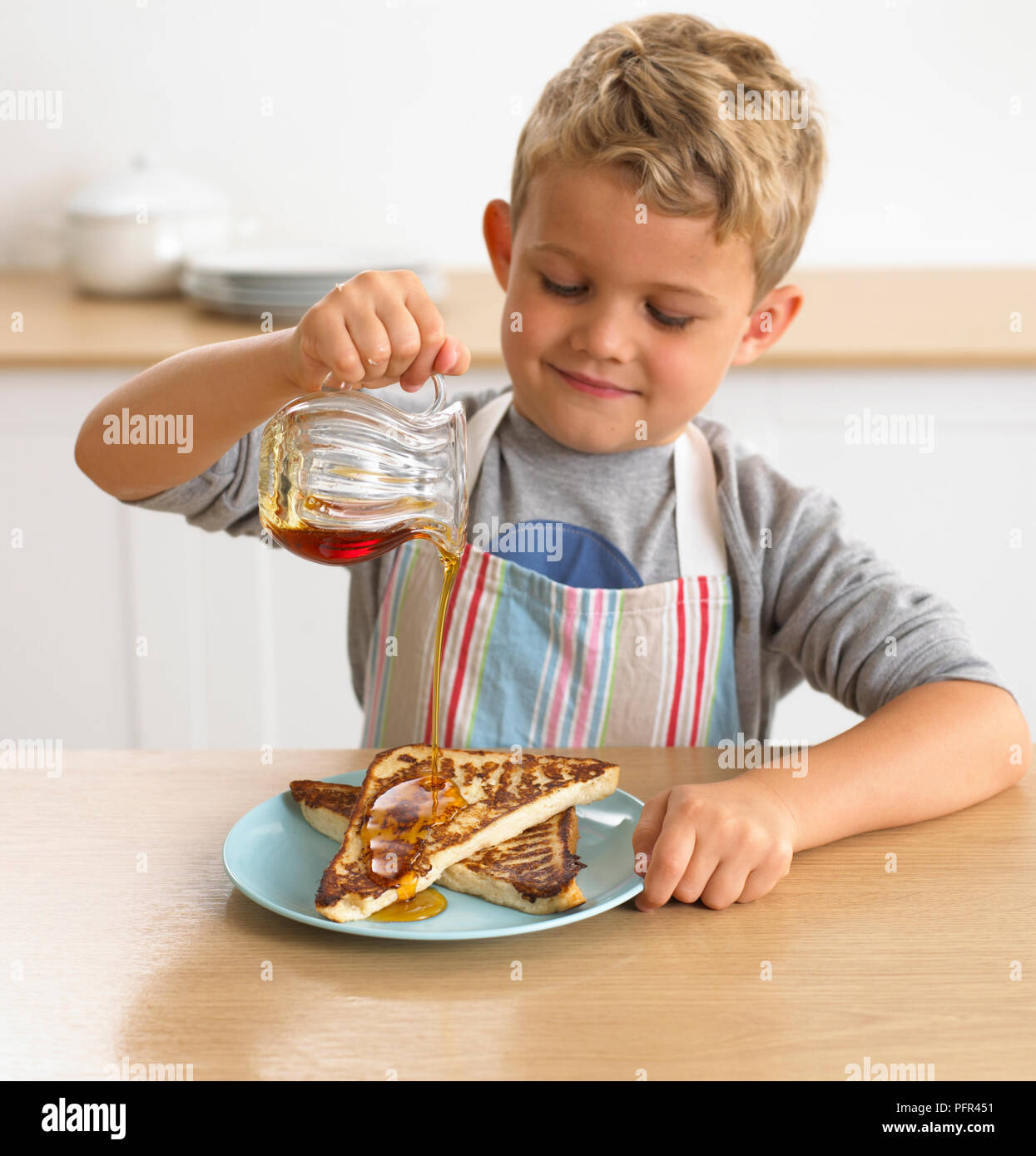 Boy pouring syrup over eggy bread, 4 years Stock Photo - Alamy