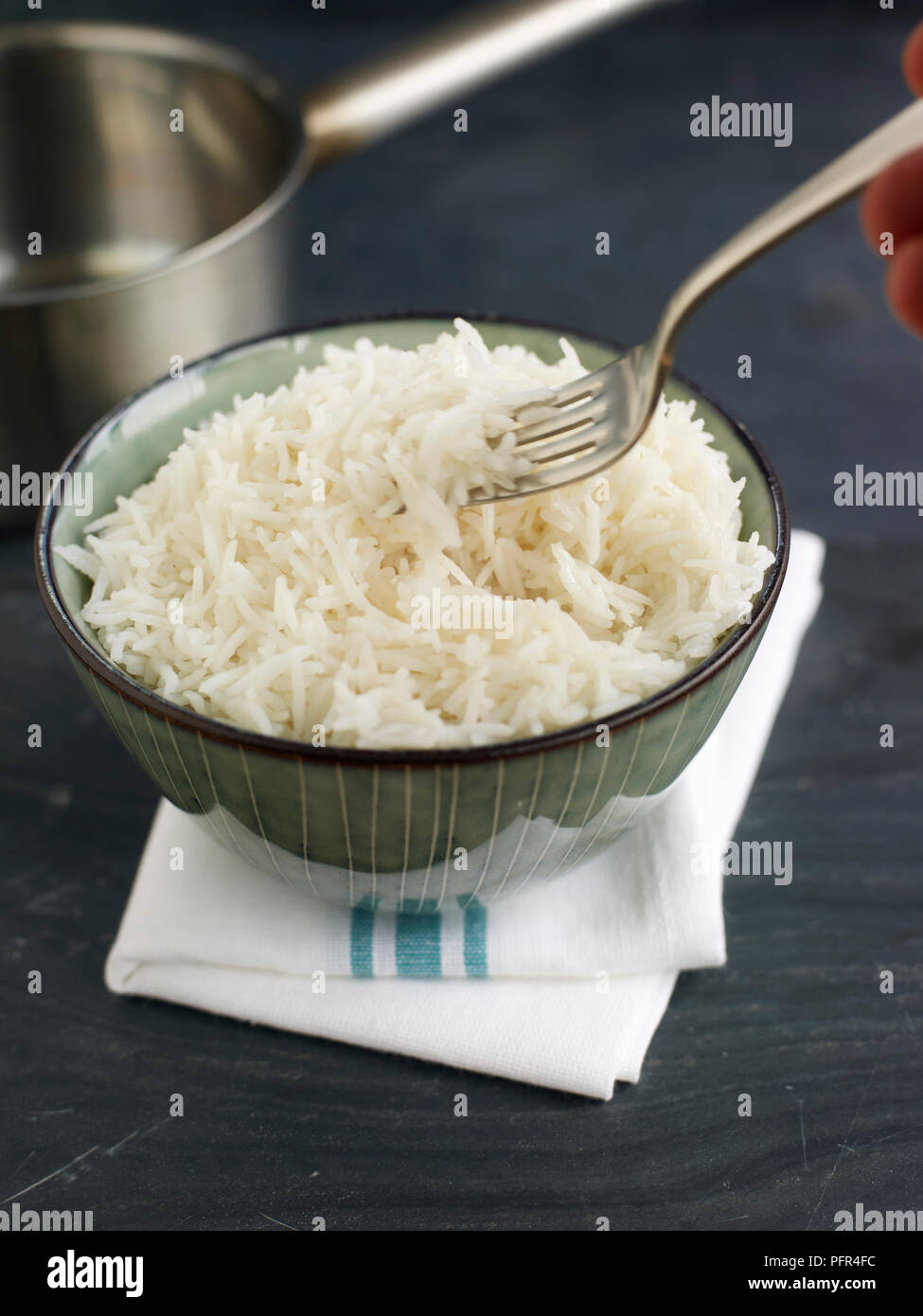 Bowl of fluffy white rice lifted with fork Stock Photo - Alamy