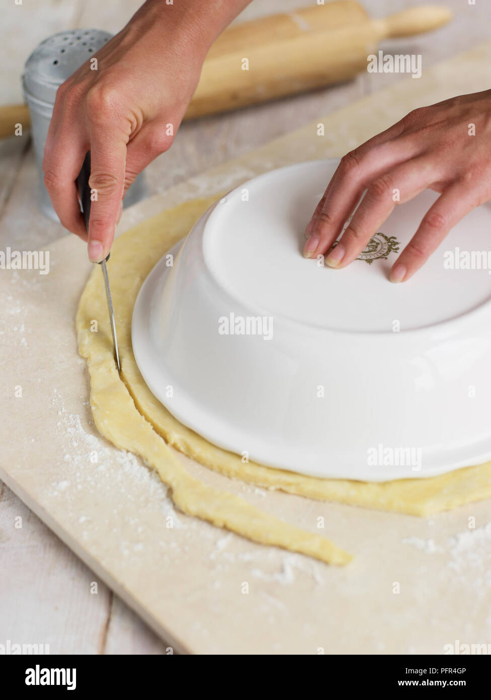 Cutting out pastry lid, around edge of upside-down pie dish Stock Photo ...