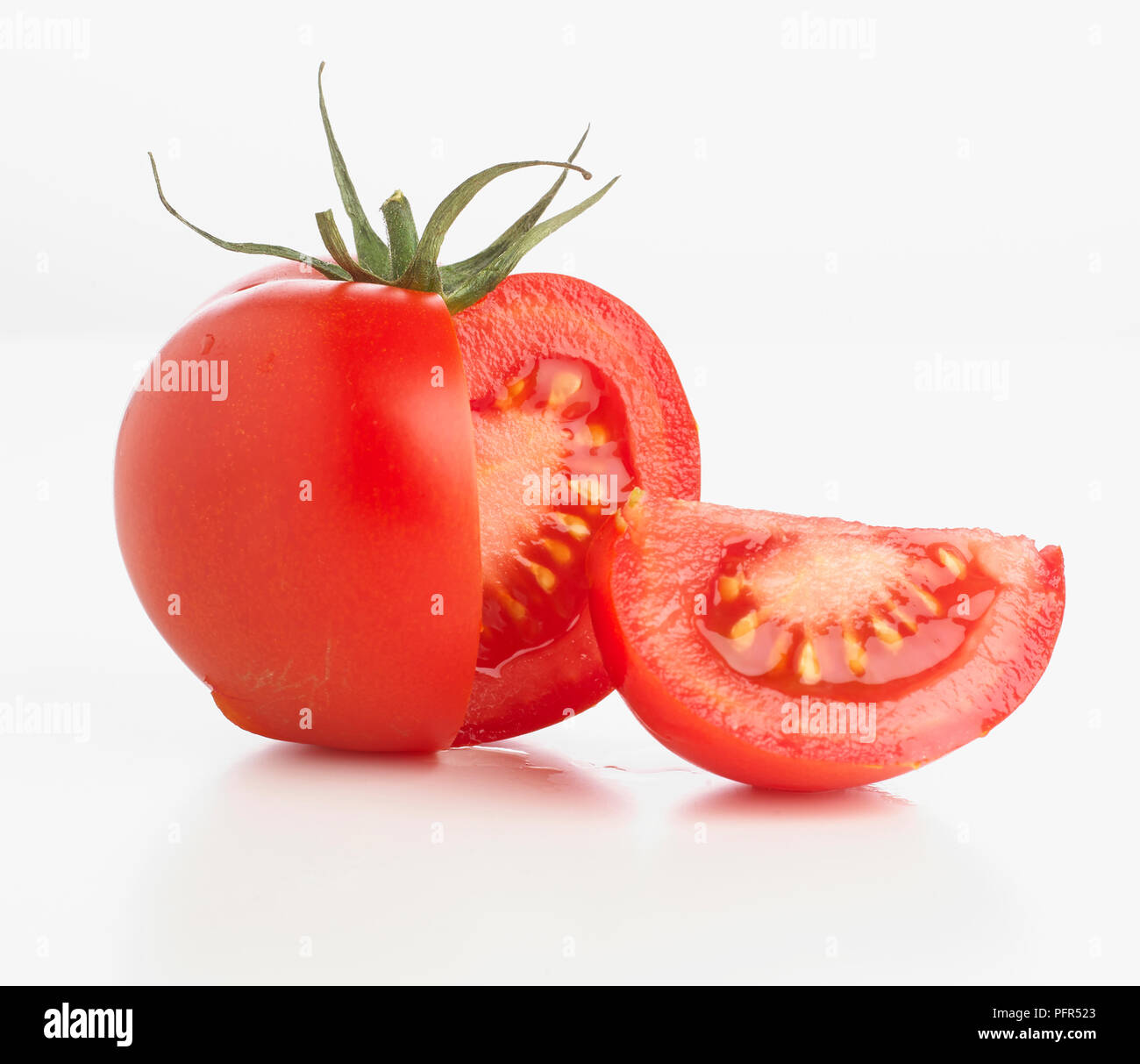 Tomato with a segment cut off Stock Photo - Alamy