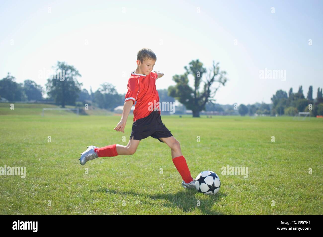 Young football player about to perform a lofted kick Stock Photo - Alamy