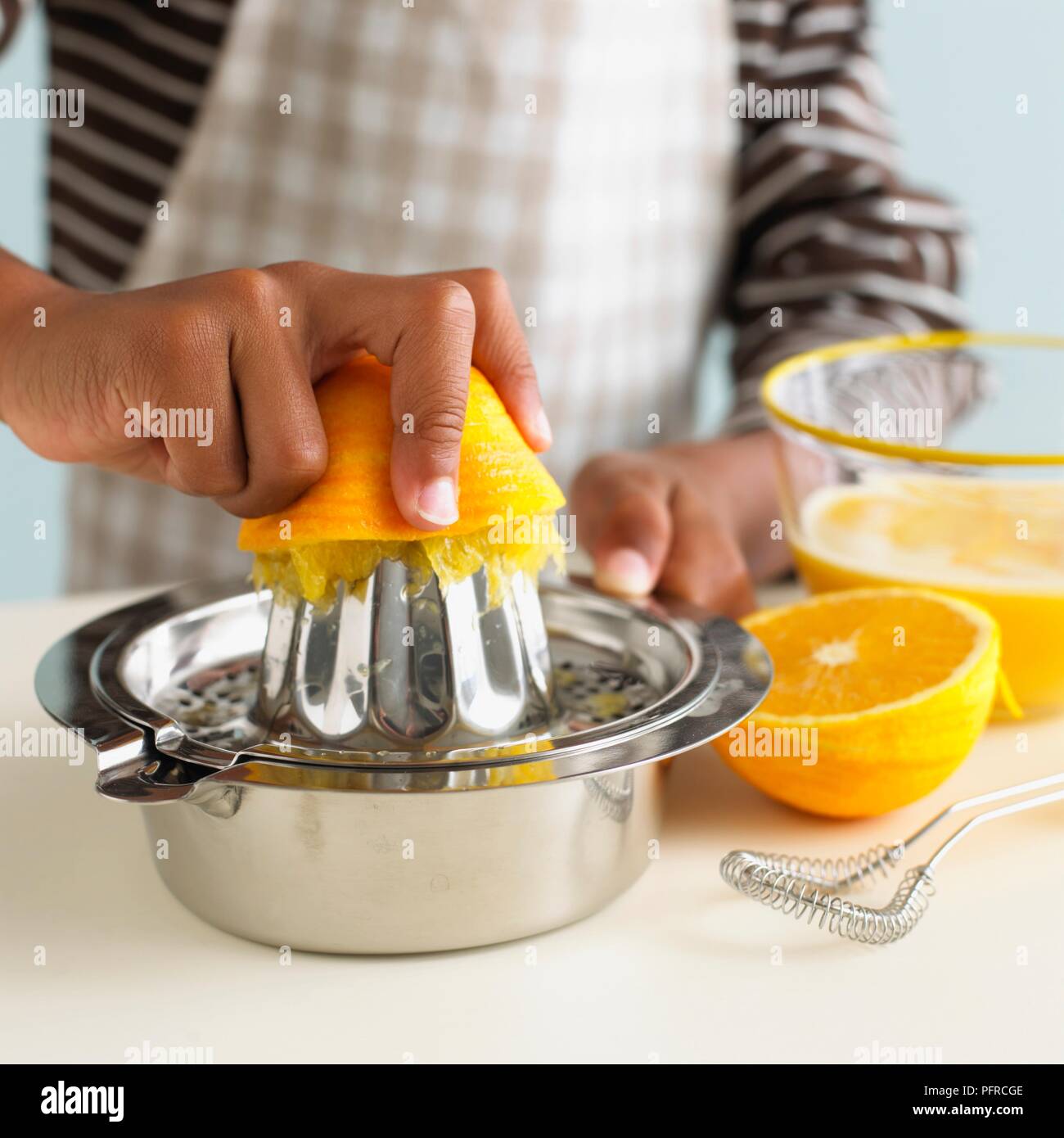 Boy squeezing orange using juice extractor Stock Photo - Alamy