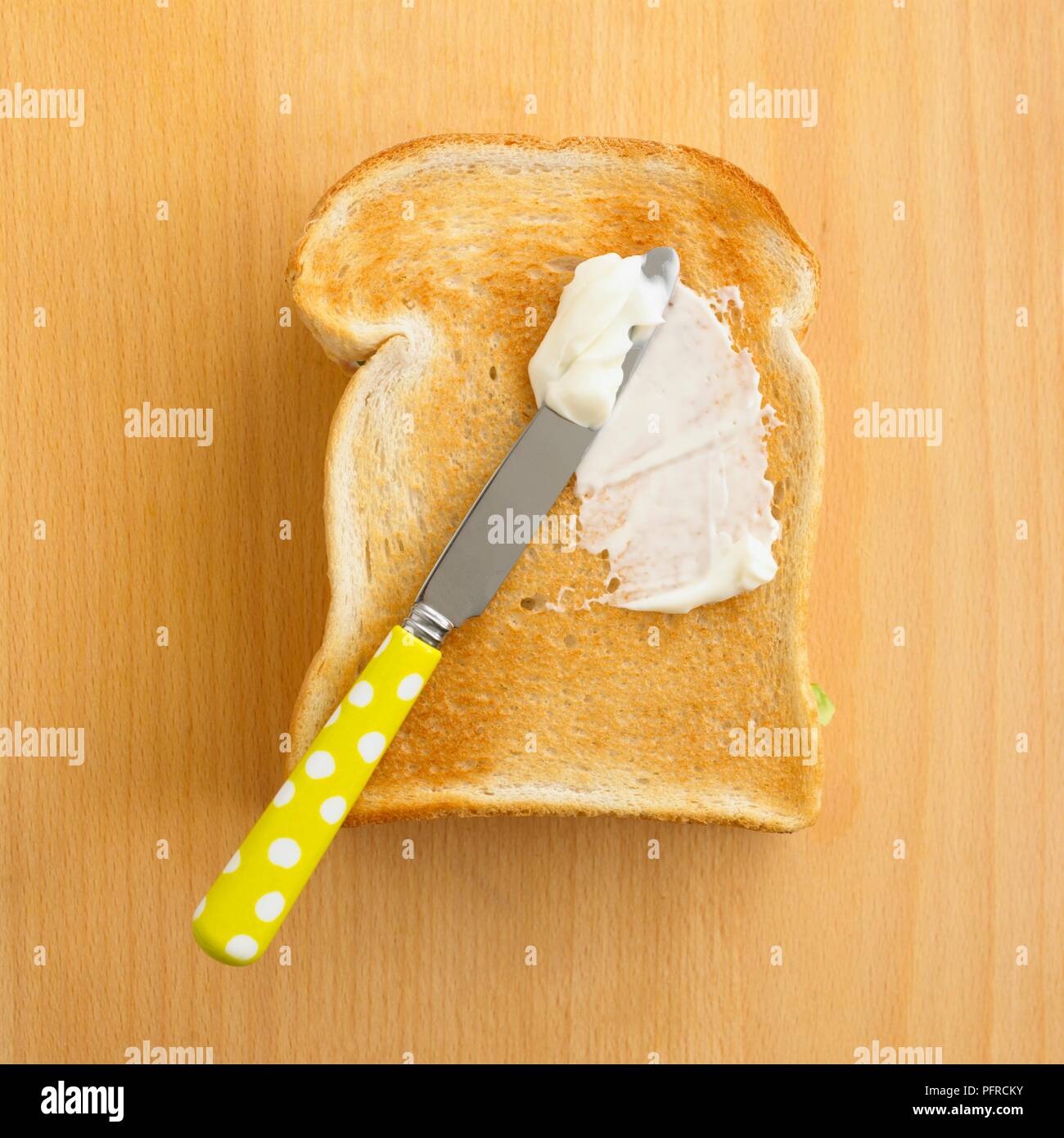 Slice of toasted white bread with knife and mayonnaise on top Stock ...