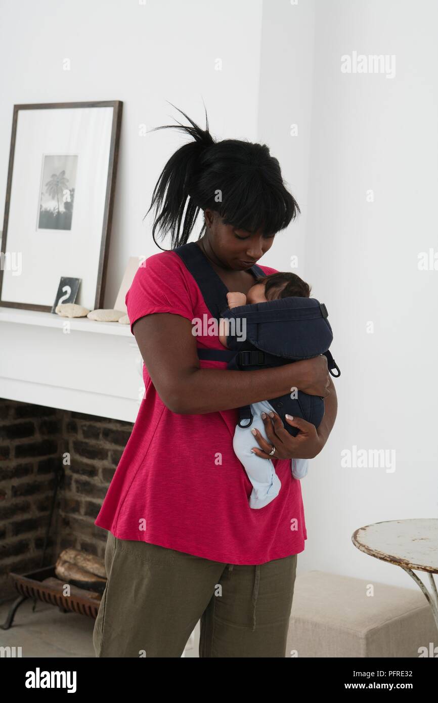 Woman carrying a baby boy in a front carrier Stock Photo - Alamy