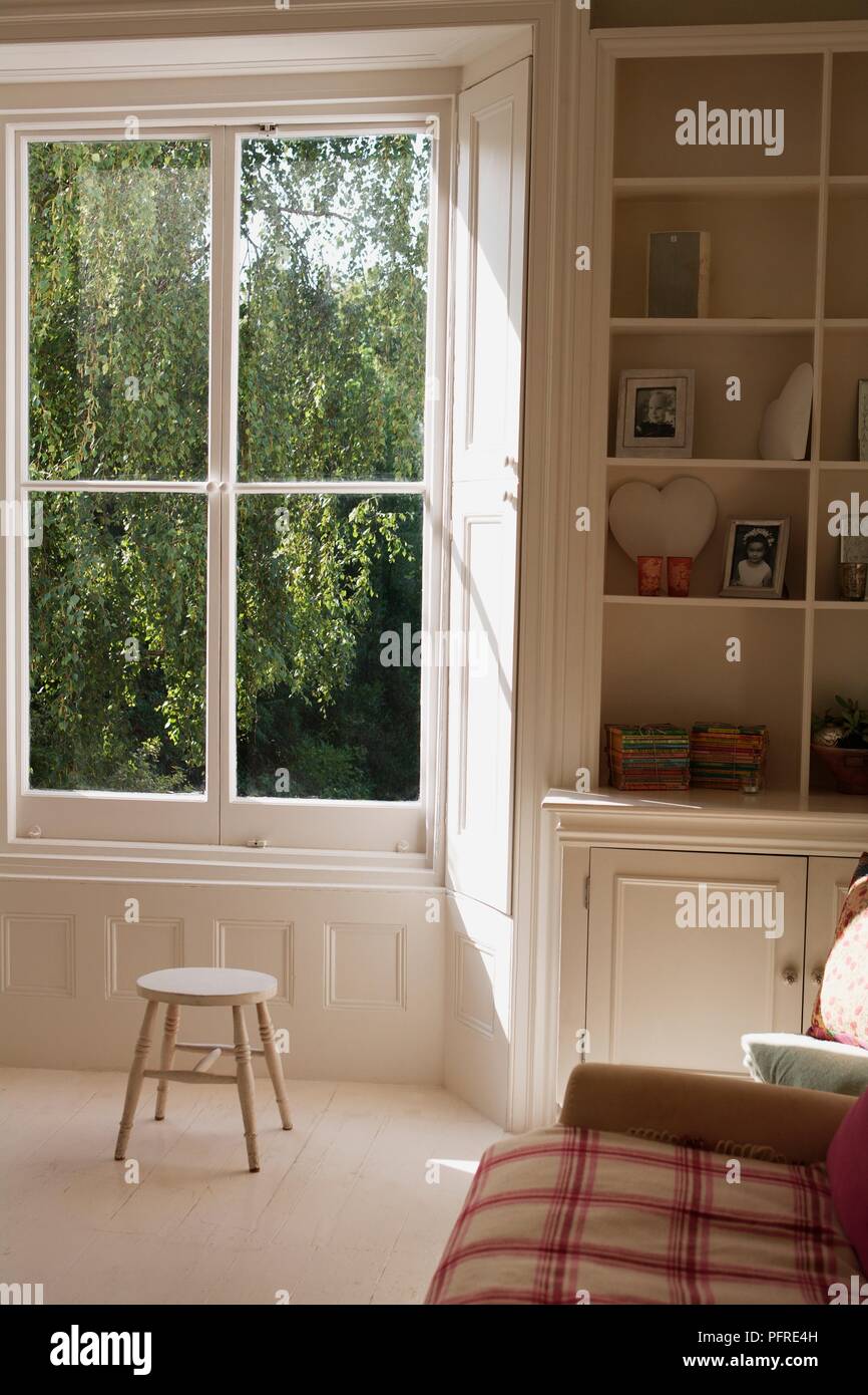 Stool near window of room in shade Stock Photo - Alamy