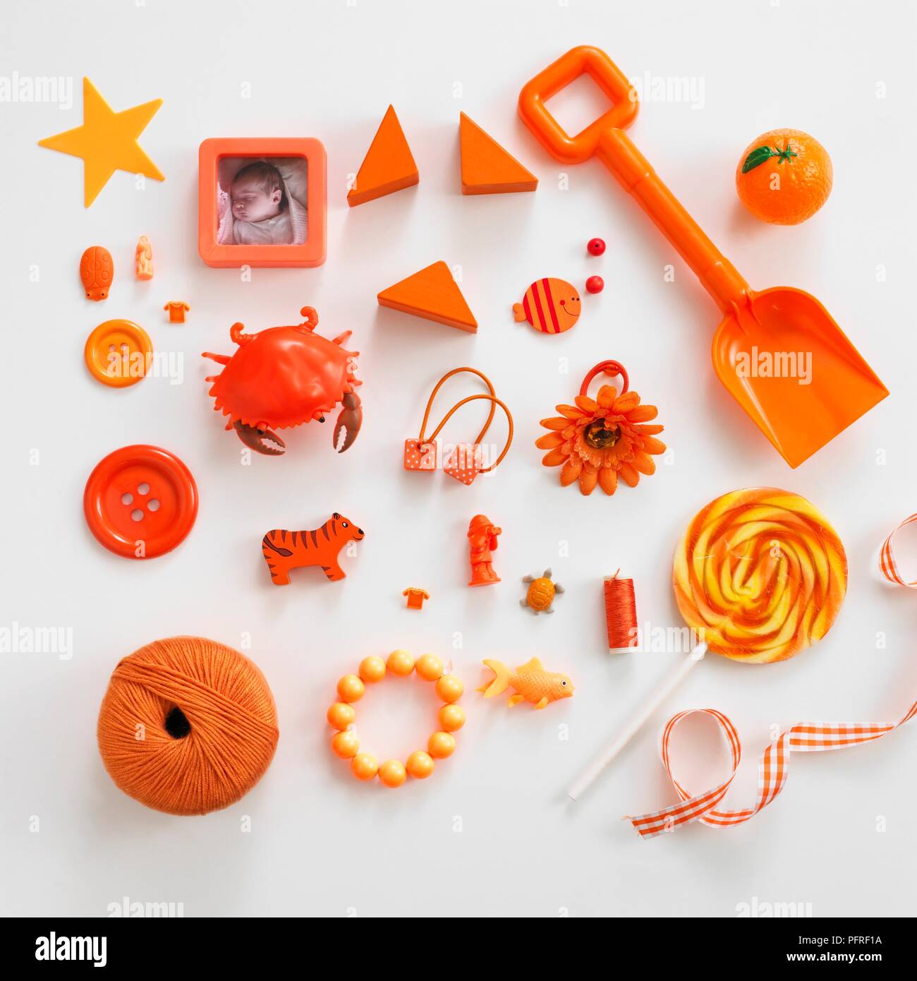 Various orange plastic toys associated with seaside and summer on white ...