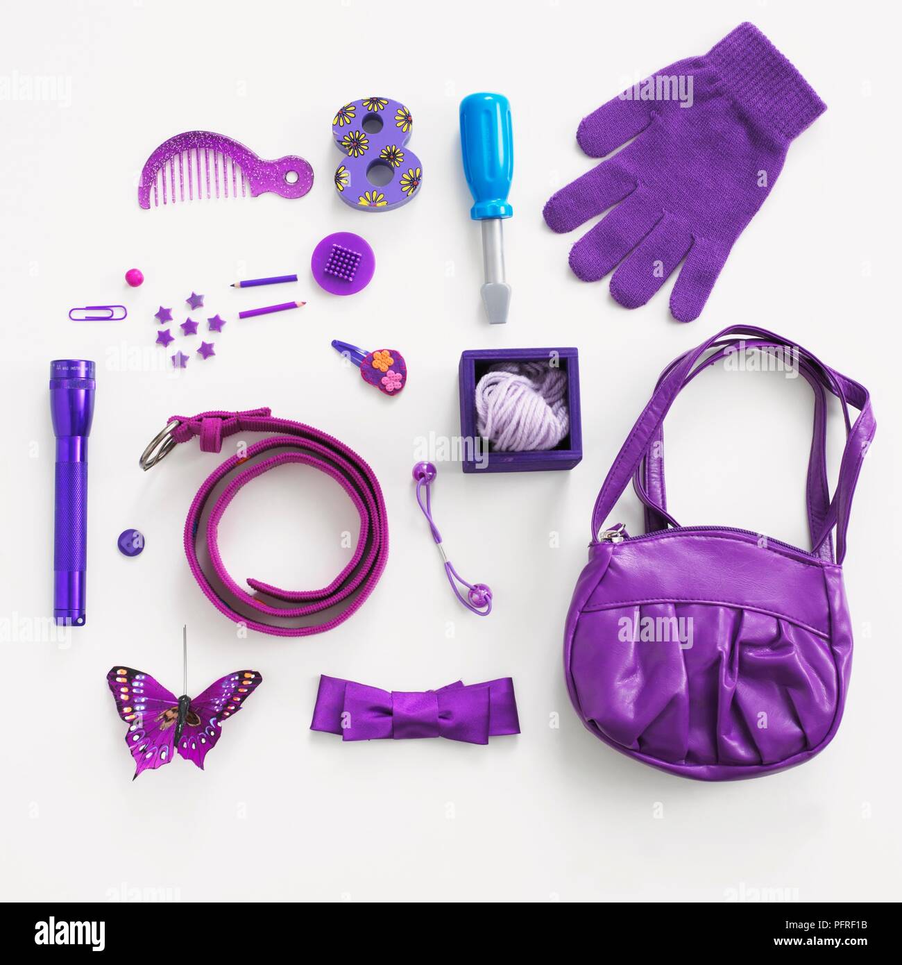 Various purple plastic toys and blue screwdriver on white background ...